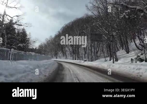 POV driving footage on a snowy rural winter highway with icy road ...