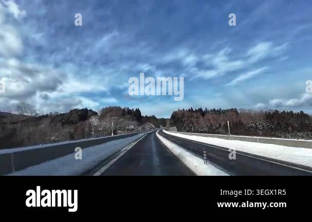 POV driving footage on a winter highway with snow-covered roadsides and ...