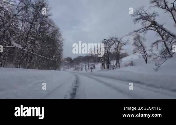 POV driving footage on a snow-covered winter forest road turning right ...