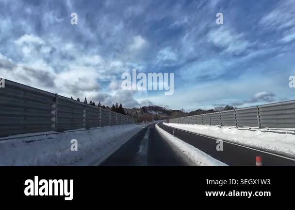 POV driving footage on a winter highway surrounded by snow fences and ...