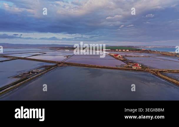 Salt pans stretch across the landscape with water reflecting the sky ...