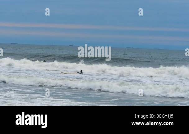 Group of people wearing protective swimsuits are in the raging sea ...