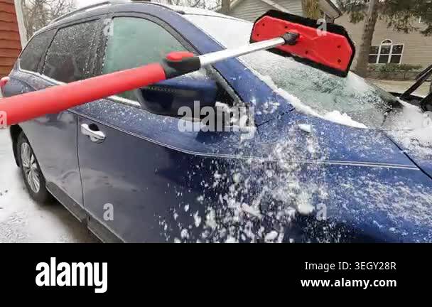 Berkeley Heights, NJ, USA - 02-07-2022: woman brushing dusting of snow ...