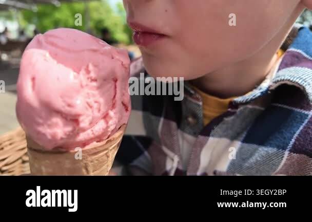 Cute child enjoying pink ice cream outside in warm sunlight. Summer ...