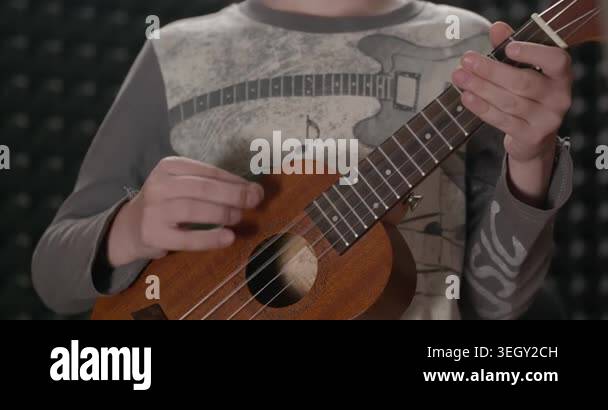 Boy Play Music on Ukulele Instrument in Home Studio. 4K 10-bit Stock ...
