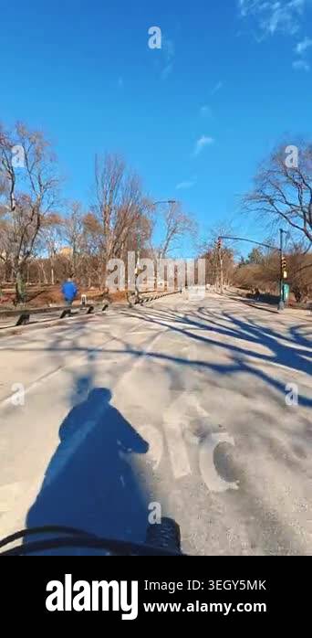 Shadow of cyclist on asphalt road in Central Park New York. Biker ...