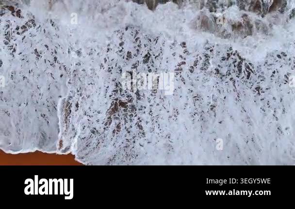 Top View Of Ocean Foam Over Orange Sand. Top-down drone view of white ...
