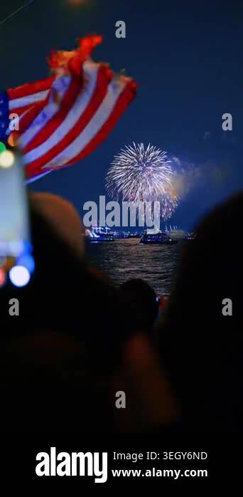 People watch and take videos of the fireworks over the water at night ...