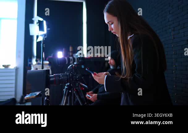 Studio Assistant Checking Smartphone Beside Video Camera. Assistant ...