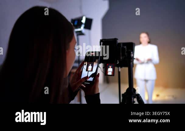 Vertical mobile phone recording of woman in white suit. Close up of ...