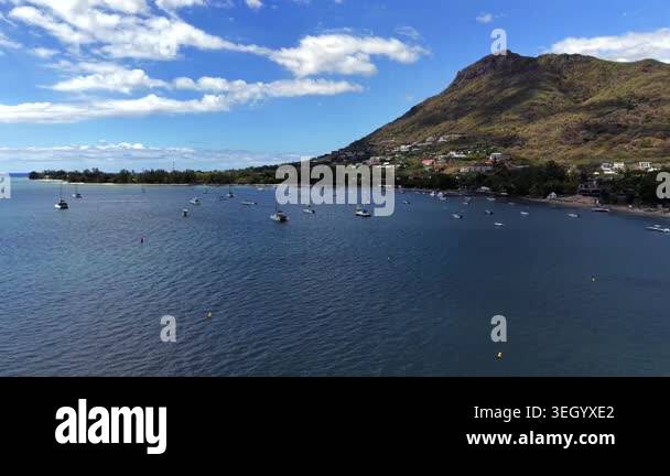 Scenic view of calm water with sailboats and a mountain in the ...