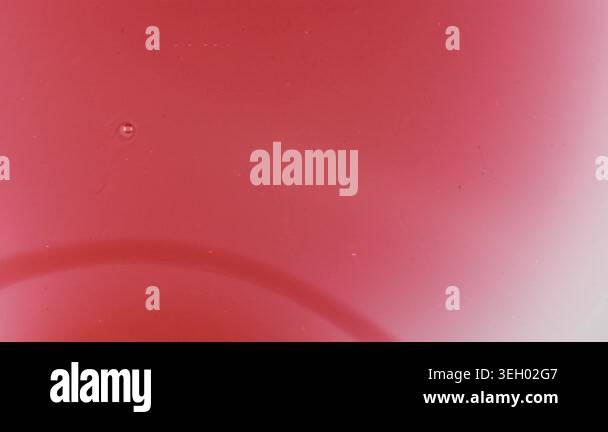 Minimalist macro shot of a red shockwave moving through liquid ...