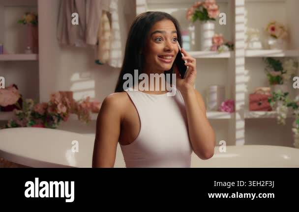 Smiling American woman happy talking chatting online with mobile phone ...