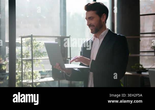 Confident Caucasian businessman typing laptop smiling in office morning ...