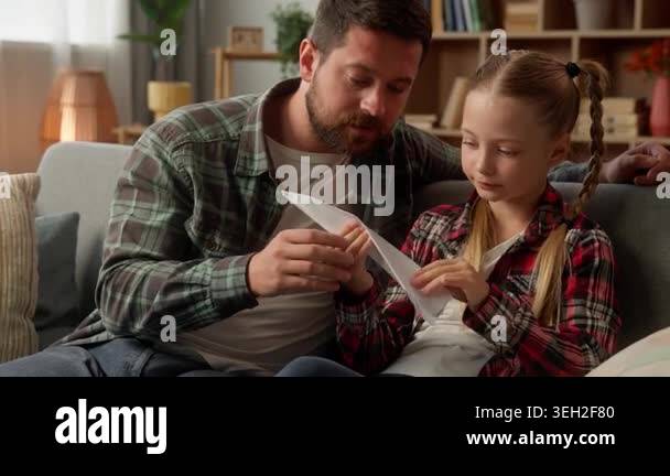 Caucasian male dad talk teaching little daughter paper airplane flying ...