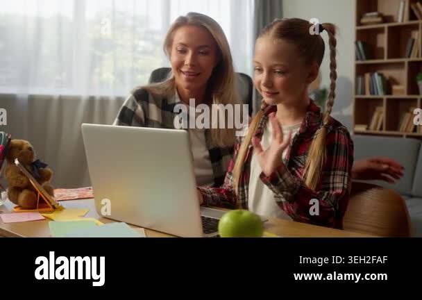 Caucasian student little girl mother waving hand laptop video call ...