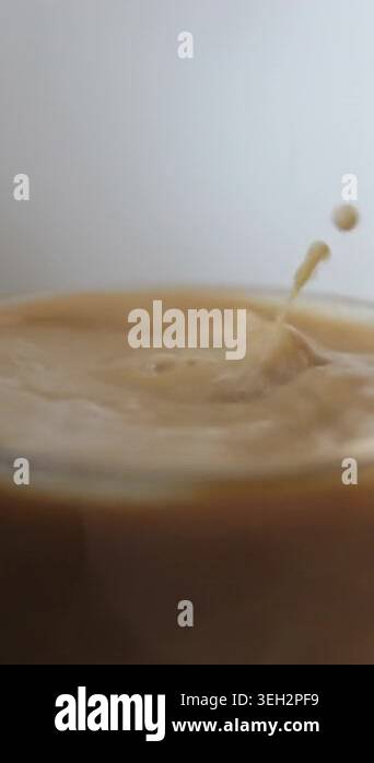 Milk drop to coffee cup and splashing up. Slow motion beverage ...