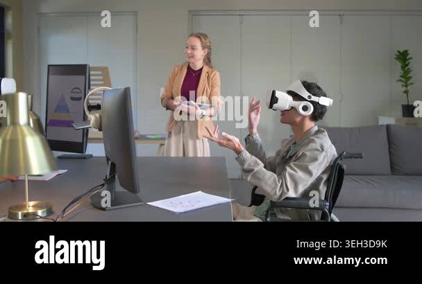 Colleague tapping tablet starting VR headset training as diverse team ...