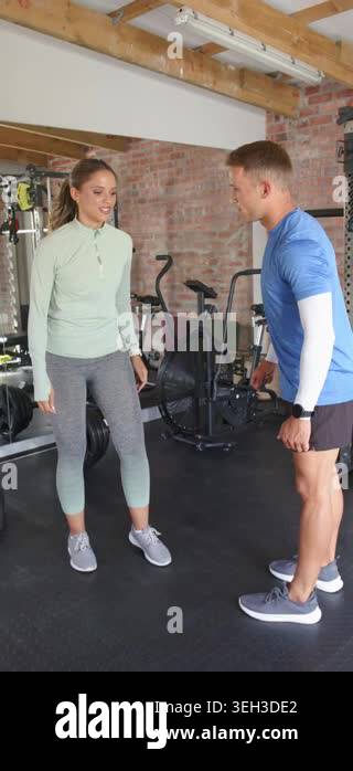Vertical video: Male coach gesturing, female client doing lateral ...