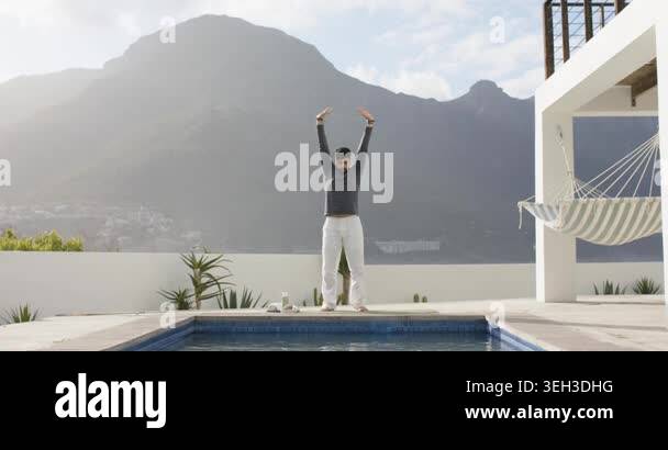 Beginning warm-up, Indian man stretching on pool deck, rotating wrists ...