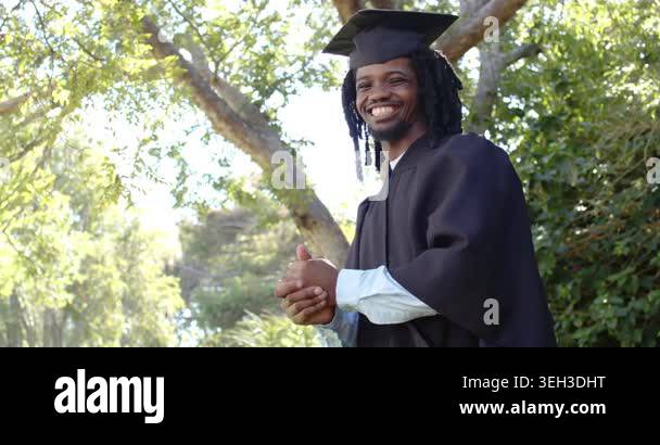 African American man clapping then resting hands at graduation beside ...