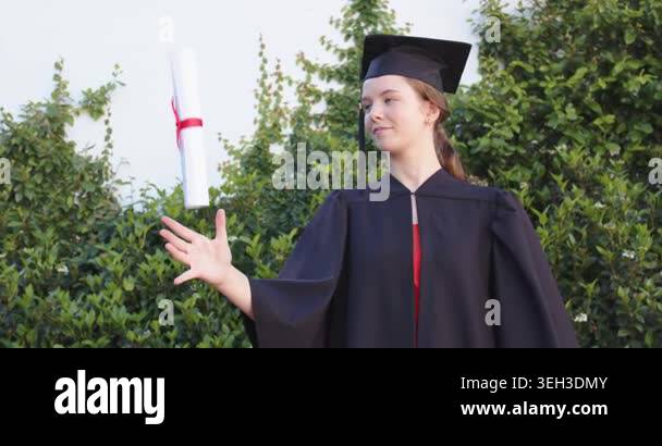 Female graduate in gown cap pulling diploma, tossing catching while ...