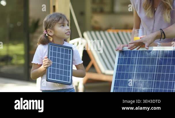 Family child looking up holding small solar panel while parents ...