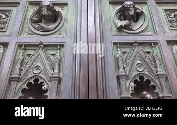 Historic bronze door with ornate relief sculptures and statues on an ...