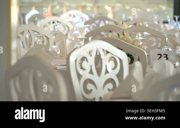 Wedding reception tables, place settings and empty chairs prepared ...