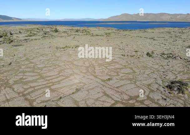 Drone aerial view shows frozen basalt lava plain with cracked rock ...