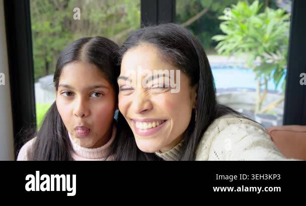 Diverse mom and daughter using smartphone snapping selfie for fun ...