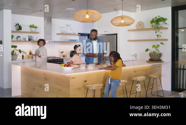 African American family preparing breakfast in modern kitchen, mother ...