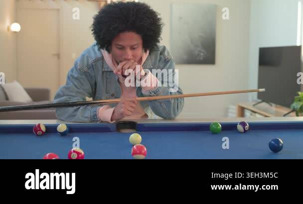 Man leaning over pool table at home studying balls, chalking cue for ...