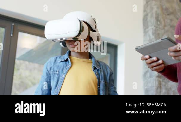 Man entering living room with tablet and positioning VR headset on ...