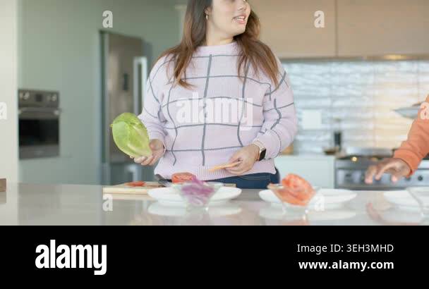 Diverse friends gesturing offering soda sparking woman slicing lettuce ...