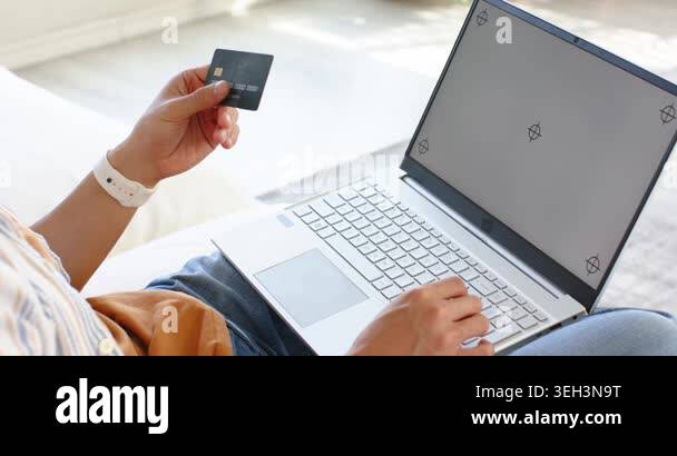Asian man checking card chip, rotating payment card, entering payment ...