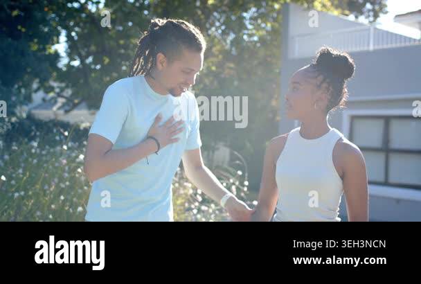 African American couple in yard, man gesturing guiding watch-wearing ...