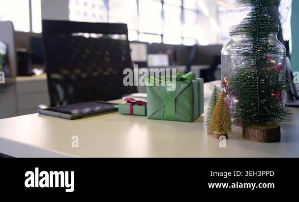 Playback starting camera panning right on office desk revealing gift ...