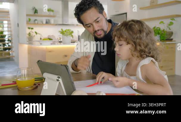 Family dad guiding daughter reacting to tablet while doing homework at ...