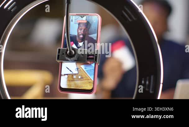 Starting ring-light phone feed African American man showing bottle ...