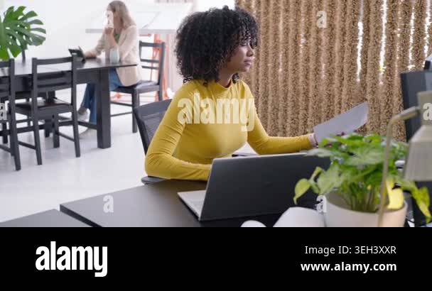 Diverse studio team, woman wearing yellow top seeing plans, reaching ...