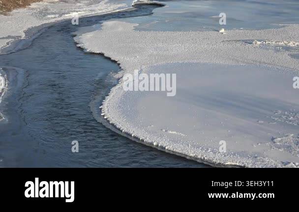 Frozen river waters with ice covered surface in extremely cold weather ...