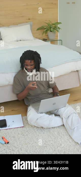 Vertical video: African man in olive tee holding device typing on ...