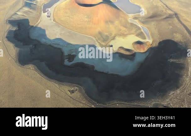 Aerial view of tuff ring cone and volcanic crater lake maar in a barren ...