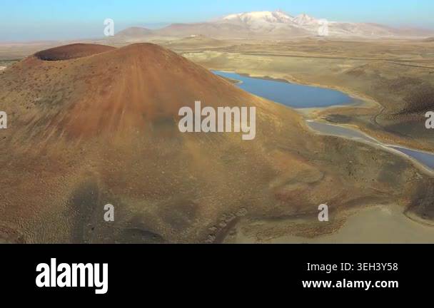 Aerial view of tuff ring cone and volcanic crater lake maar in a barren ...