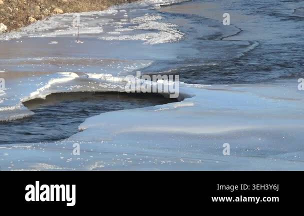 Frozen river waters with ice covered surface in extremely cold weather ...