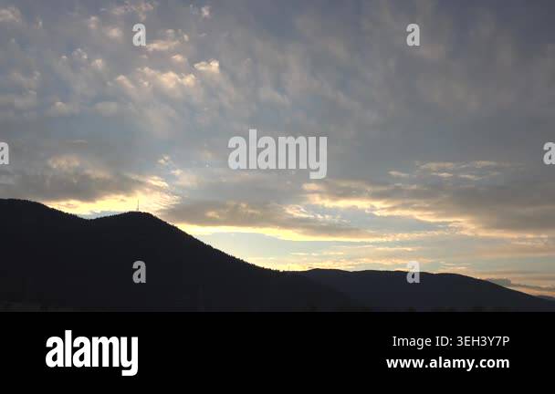 Timelapse sunset clouds drift above forested mountains in western Peru ...