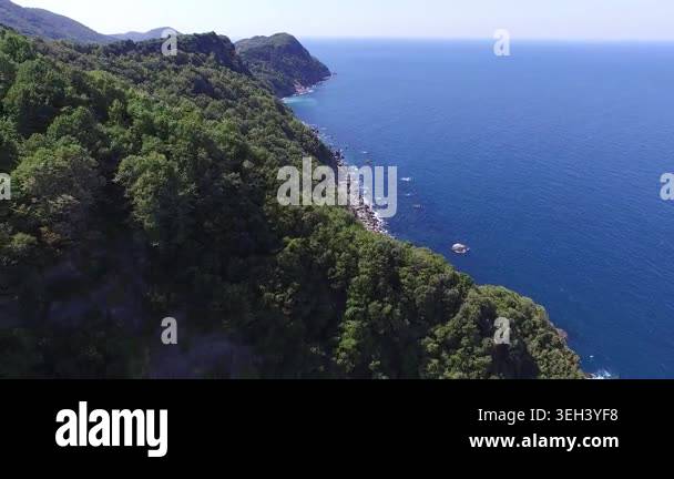 Aerial view of rugged coastline with high mountains meeting tropical ...