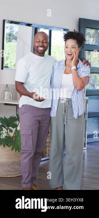 Vertical video: African American couple standing in entry man showing ...