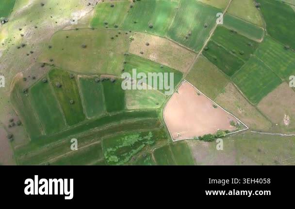 Aerial farmland patchwork fields hills cultivated plains rural terrain ...